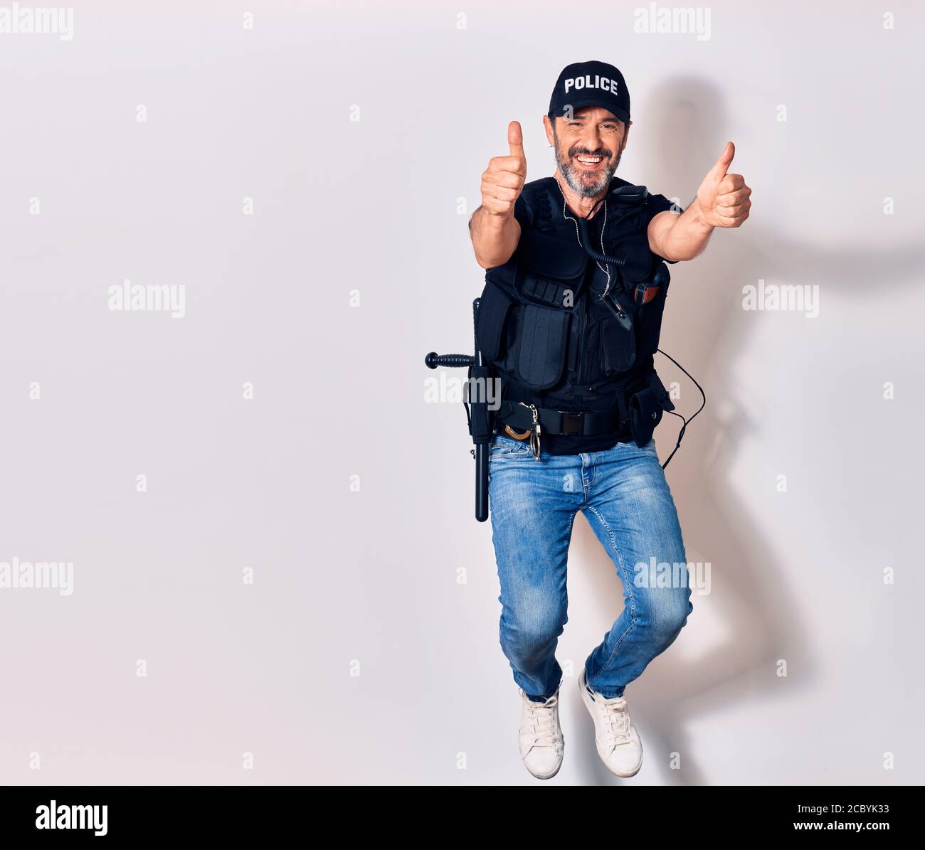 Middle age handsome man wearing police unifrom smiling happy. Jumping ...