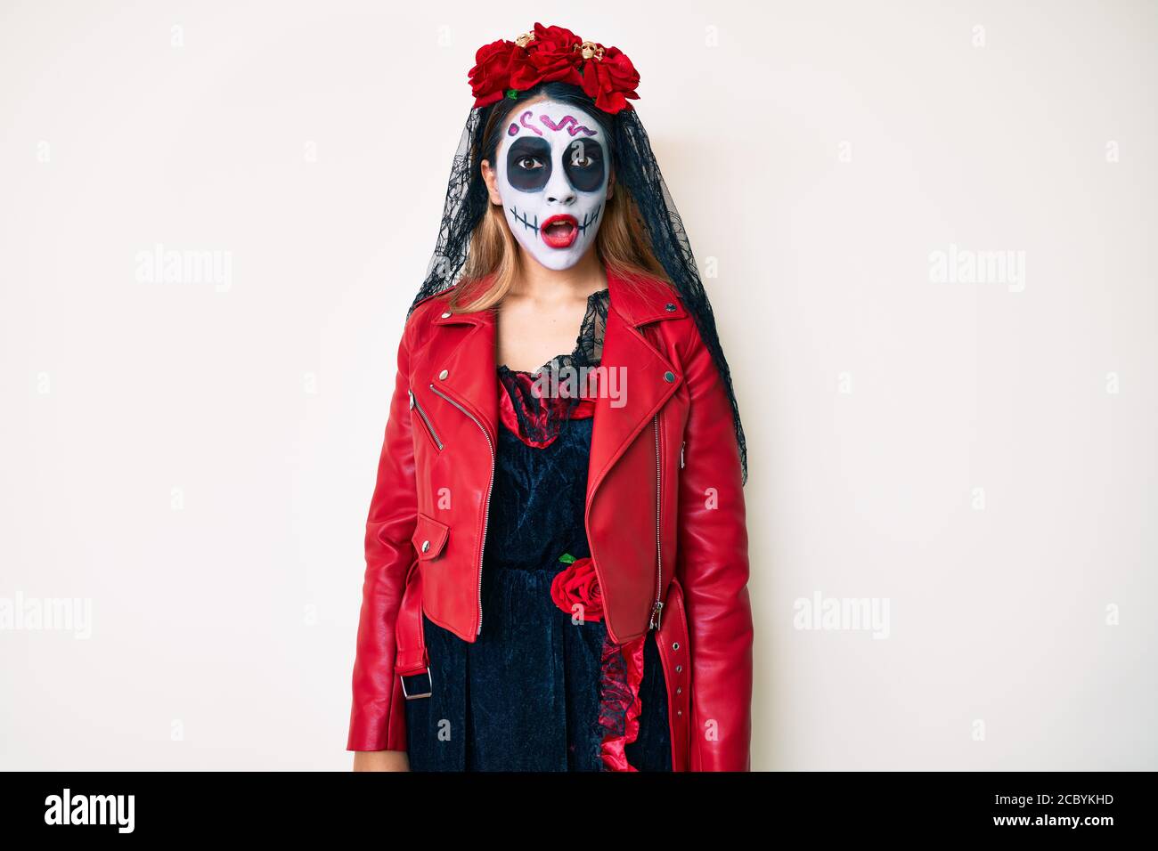 Woman wearing day of the dead costume over white in shock face, looking ...