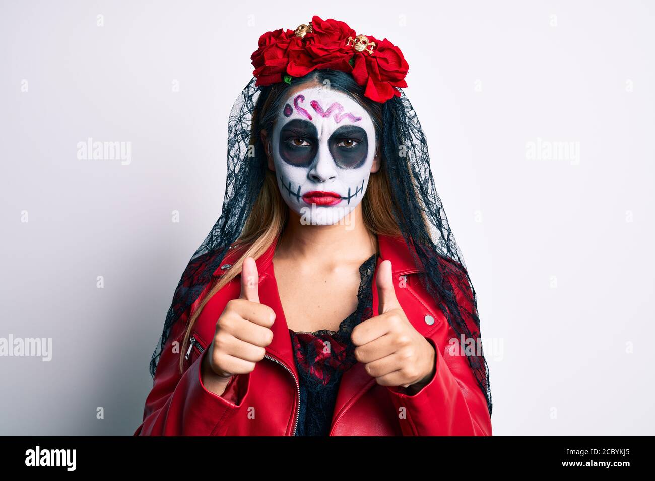 Woman wearing day of the dead costume with thumbs up doing ok sign ...