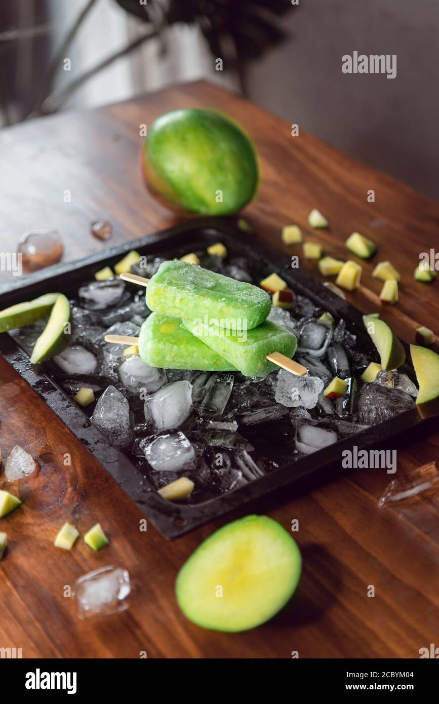 Homemade green mango ice cream or popsicles garnishes with mango chunks ...
