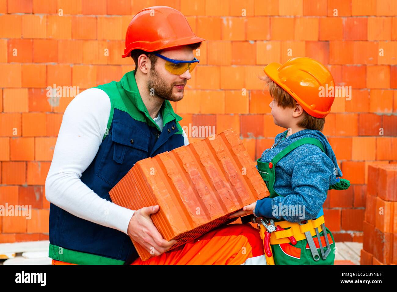 Little boy bricklayer. Brothers are building together. Brbuilder work ...