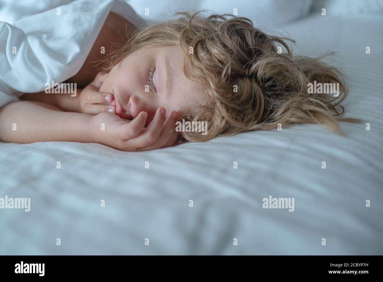 Kids on sleeping bed, happy bedtime in white bedroom. Kid sleep in bed ...