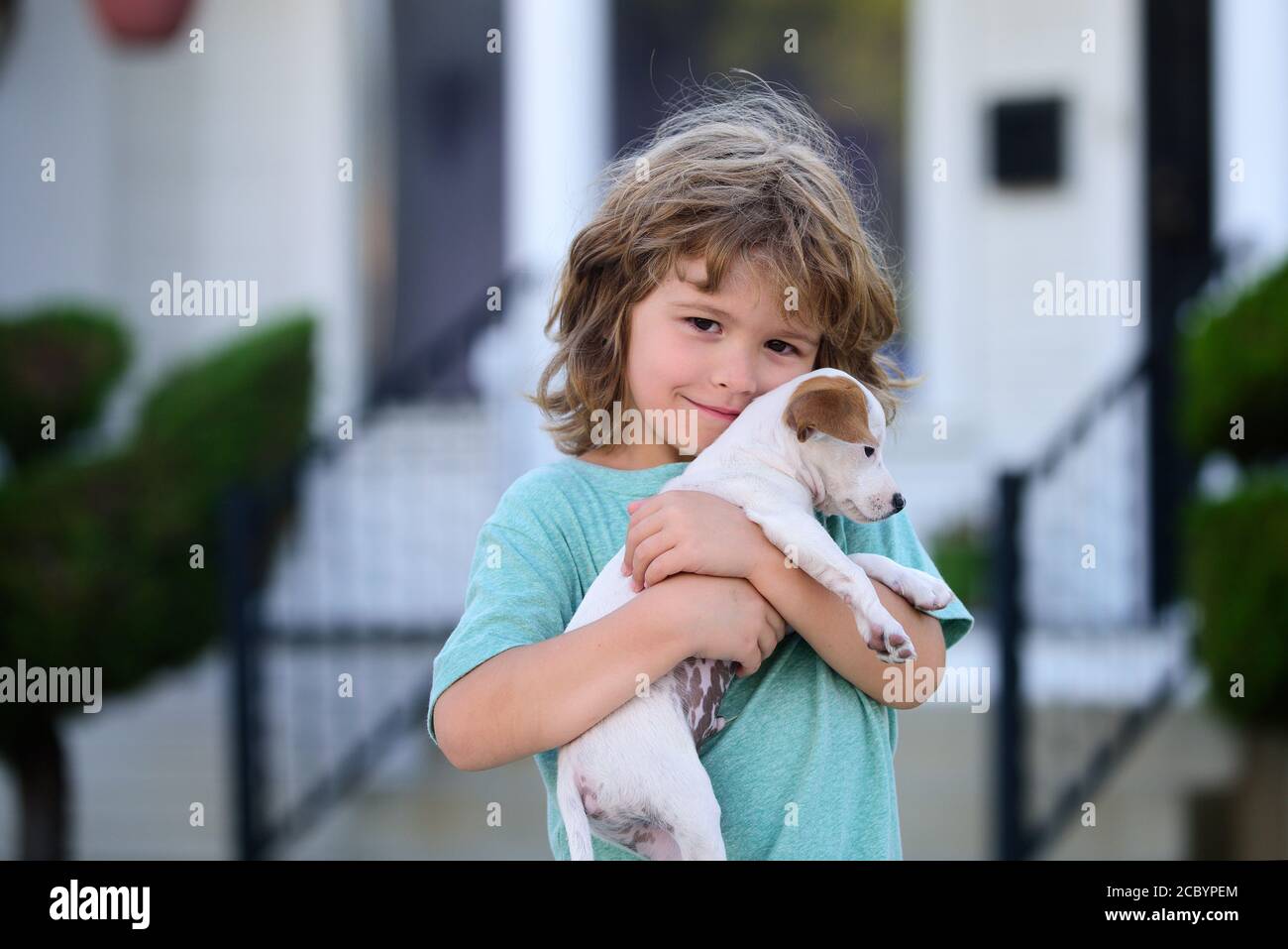 Cute child and dog hugs her with tenderness smiling. Portrait kid boy ...