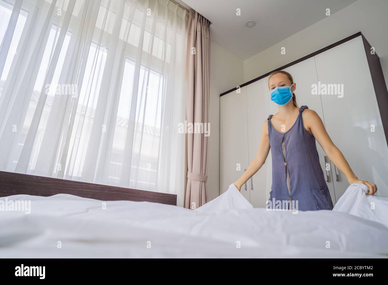 Young Female Housekeeper wearing a medical mask due to coronavirus ...