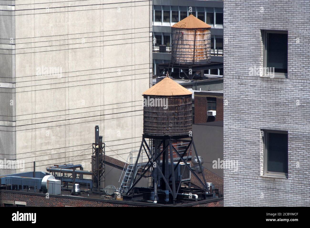 Water tanks on the roofs of an old building among skyscrapers in ...