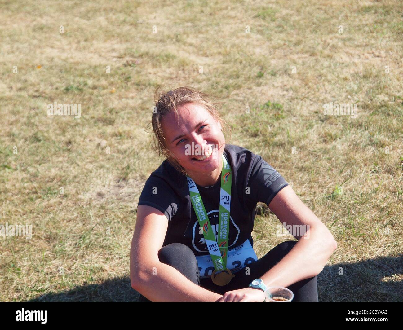 Portrait of a beauty woman with perfect smile. Runner sitting on track ...