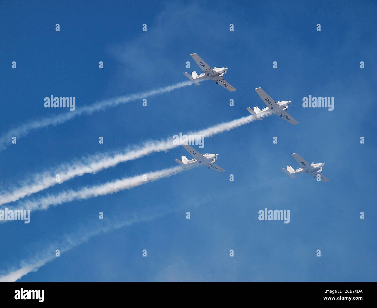 Light engine airplanes with a trace of white smoke fly in groups in the ...