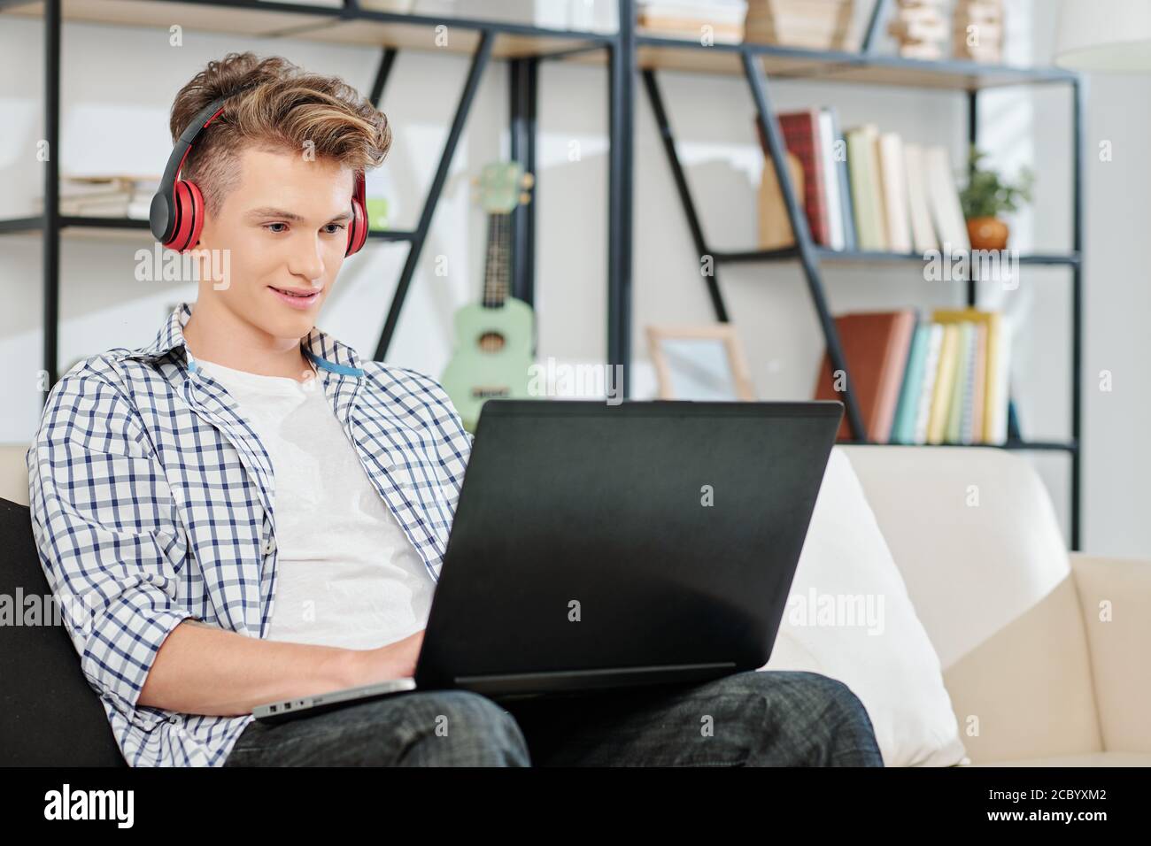Teenage boy playing on laptop Stock Photo - Alamy