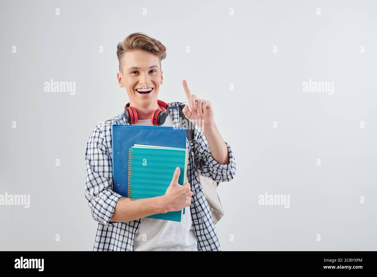 Student with books pointing in the air Stock Photo - Alamy