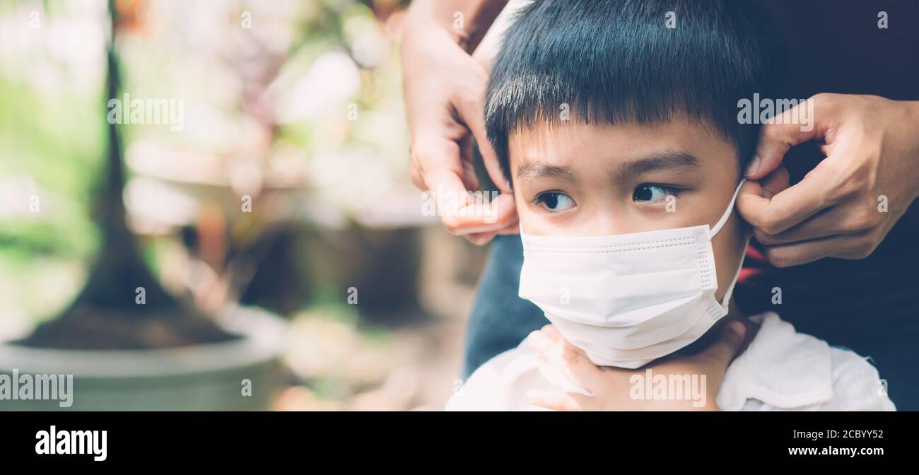 Mother take care son with face mask for protection disease flu or covid ...