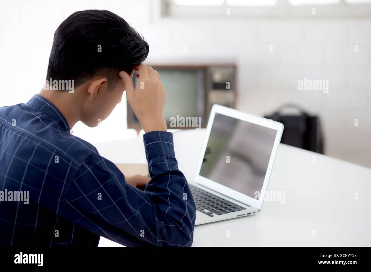 Young asian business man headache during working on laptop computer ...