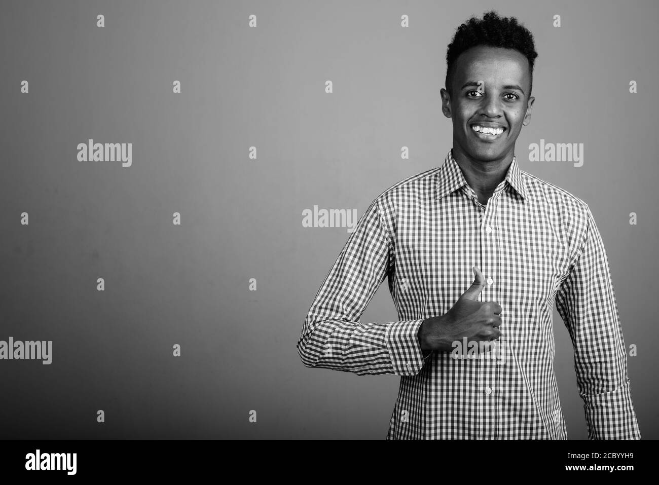 Young handsome African businessman against gray background Stock Photo ...
