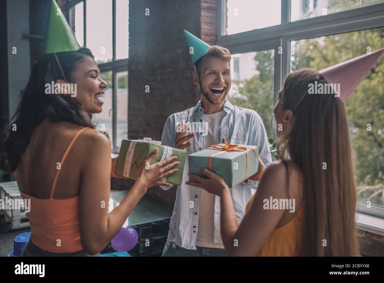 Amazed man receiving a lot of gifts from his friends Stock Photo - Alamy