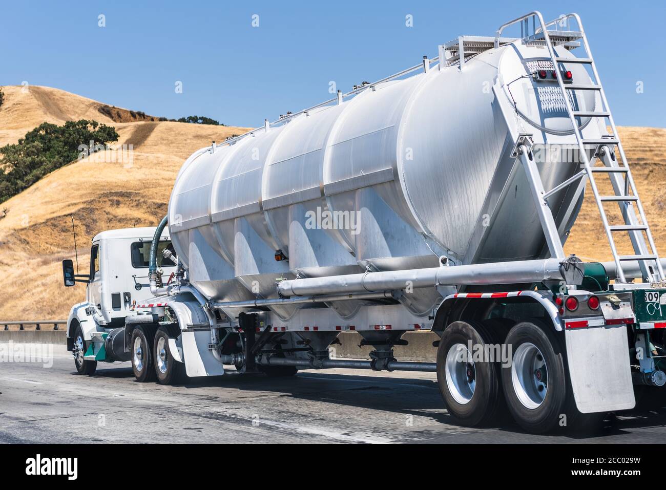 Tanker truck driving on the freeway through the hills of Alameda County ...