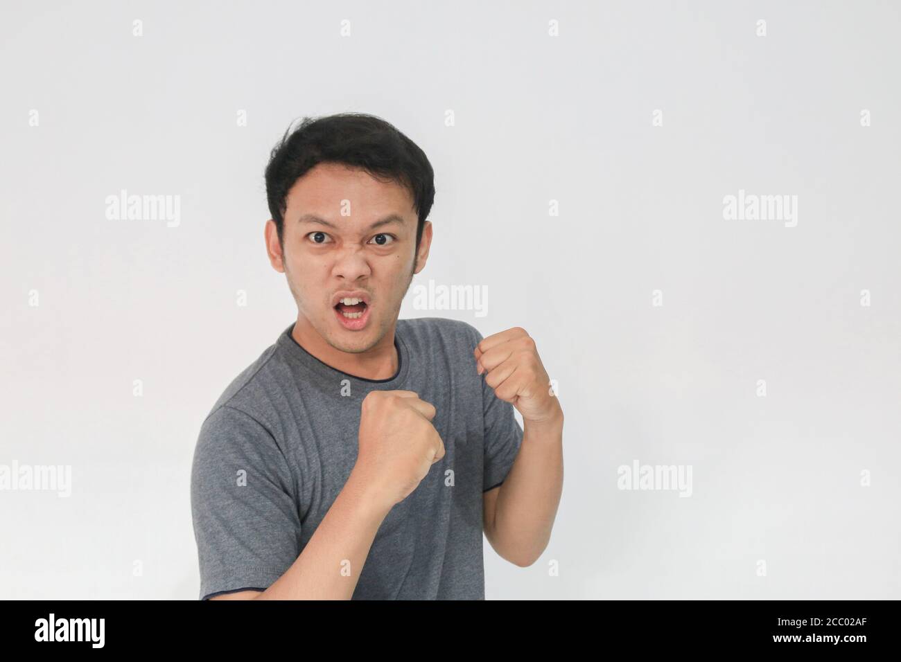 Angry and hate face of young Asian man in gray t-shirt with angry hand ...
