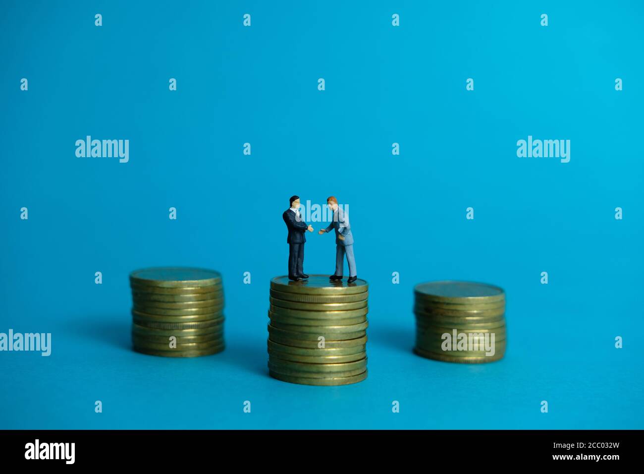 Miniature business concept - two businessman make an handshake for ...