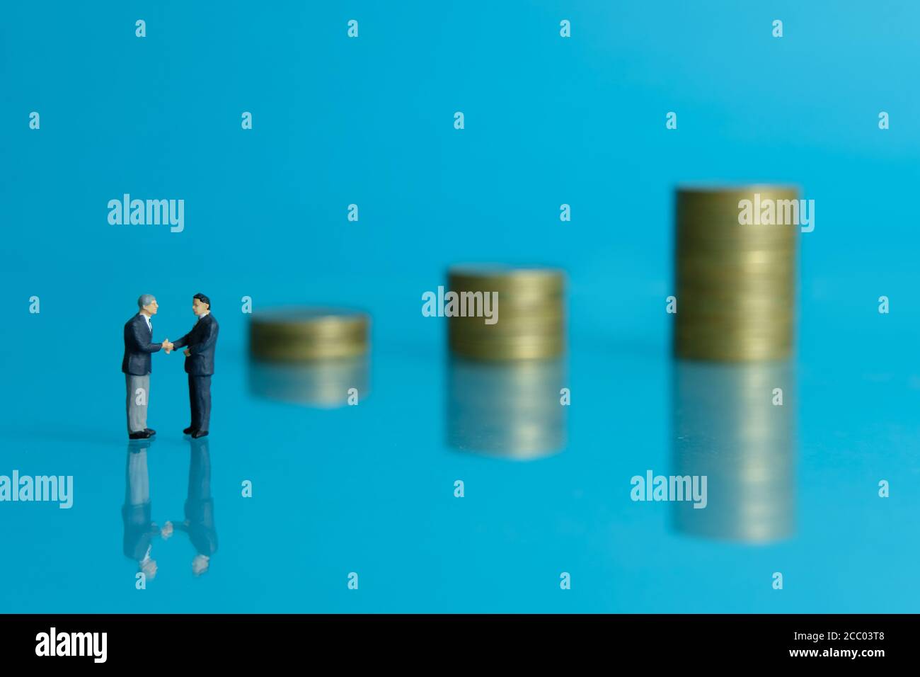 Miniature business concept - two businessman make an handshake for ...