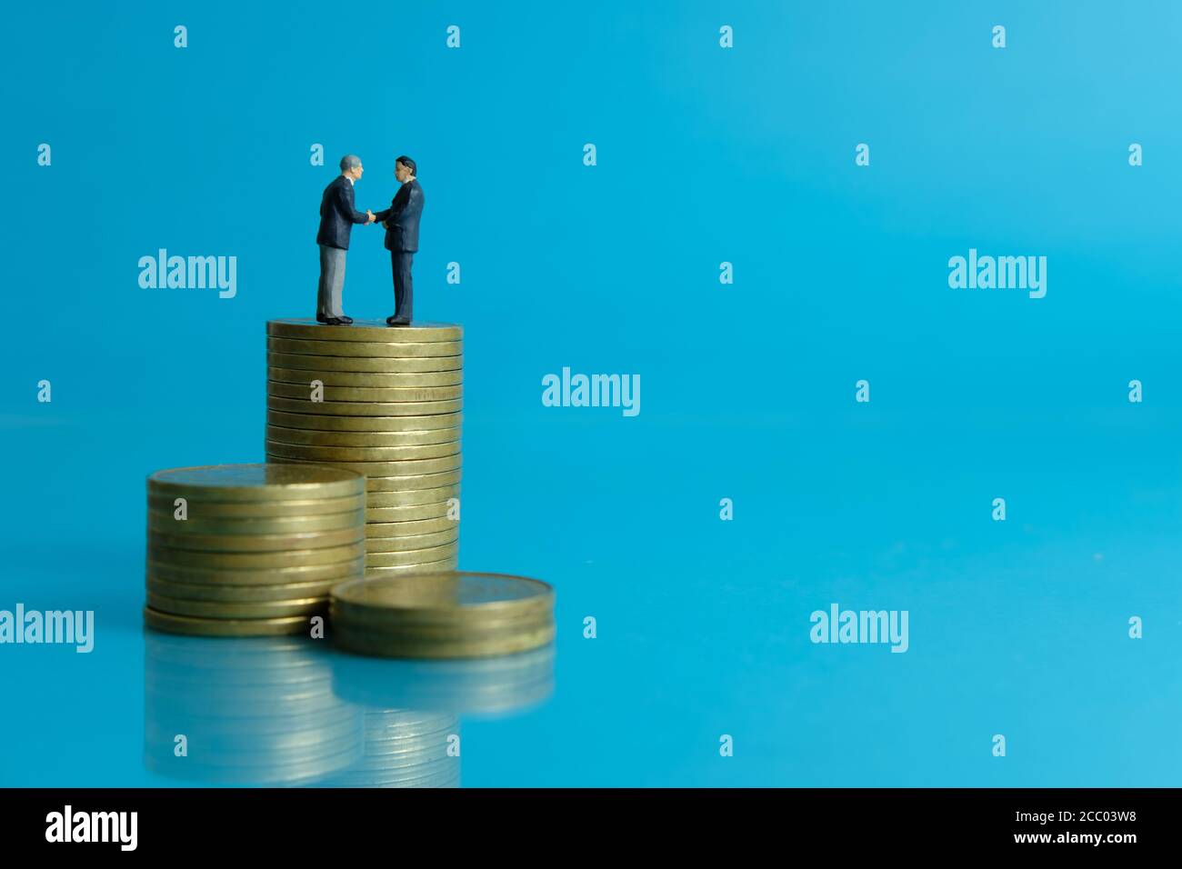 Miniature business concept - two businessman make an handshake for ...