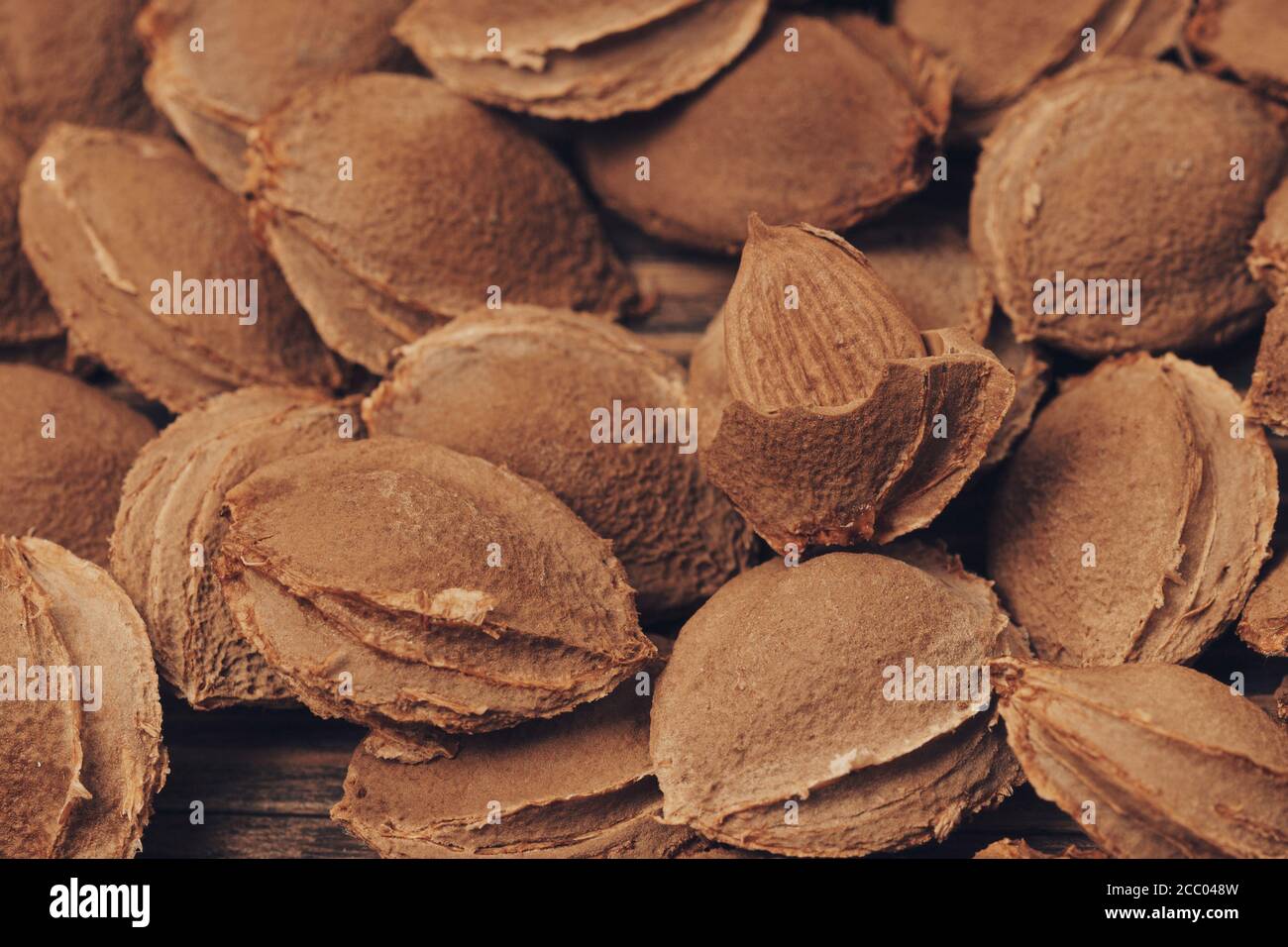 apricot pits and kernels on a rustic wooden scratched board . Healthy ...