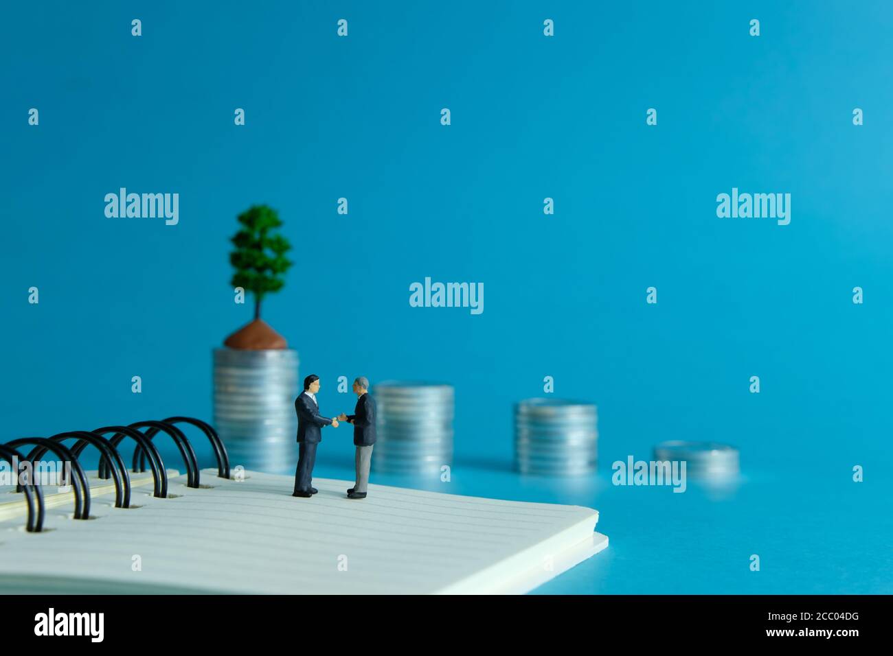 Miniature business concept - businessman make an agreement above book ...