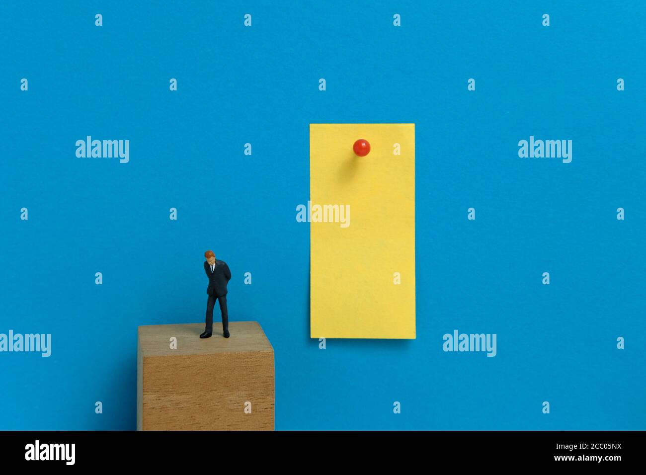 Miniature people business concept - a man standing beside blank sticky ...