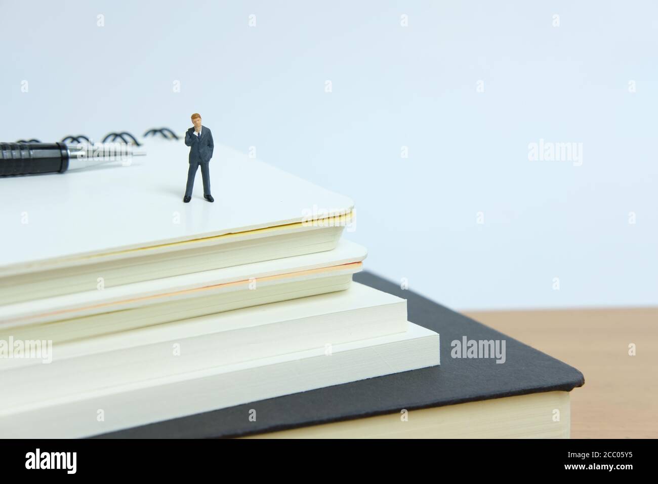 Miniature business concept - thinking a resolution. Mini figure with ...
