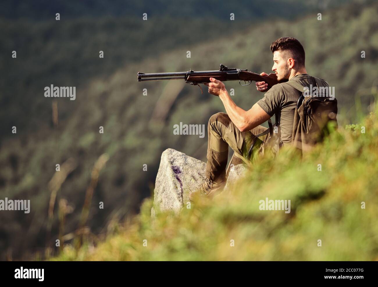 soldier in the field. combat readiness. muscular man hold weapon ...