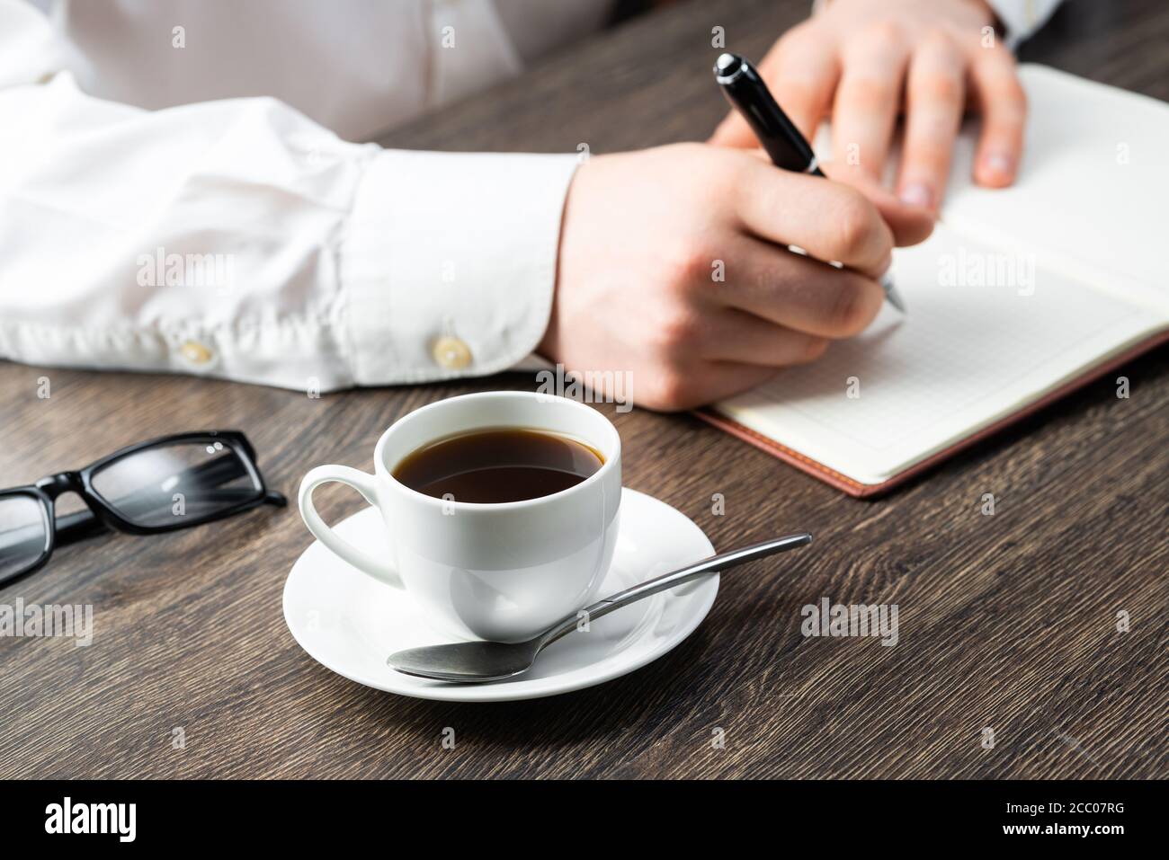 Man making notes with pen in notebook Stock Photo - Alamy