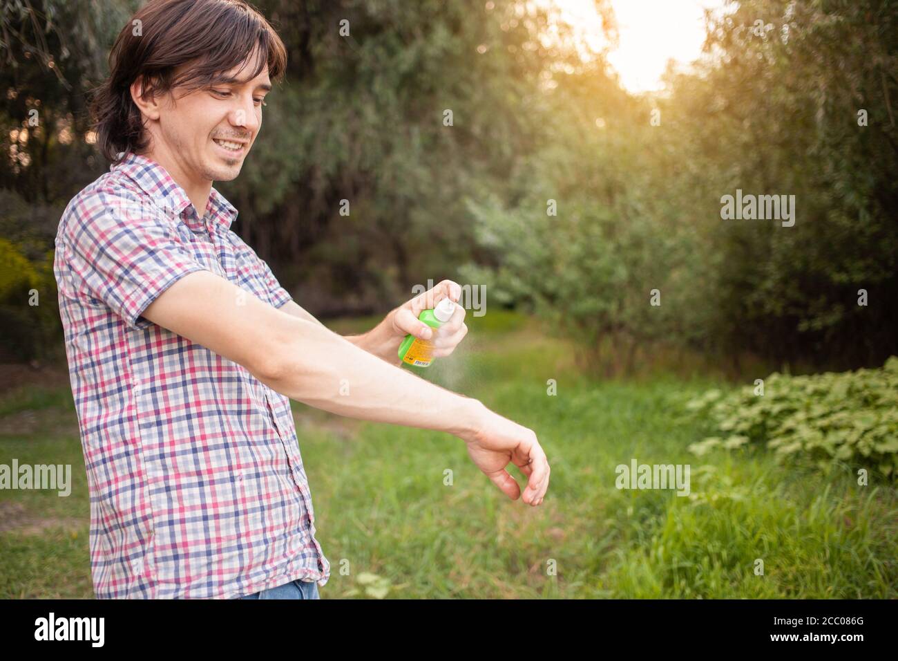Young man spraying mosquito insect repellent in the forrest, insect ...