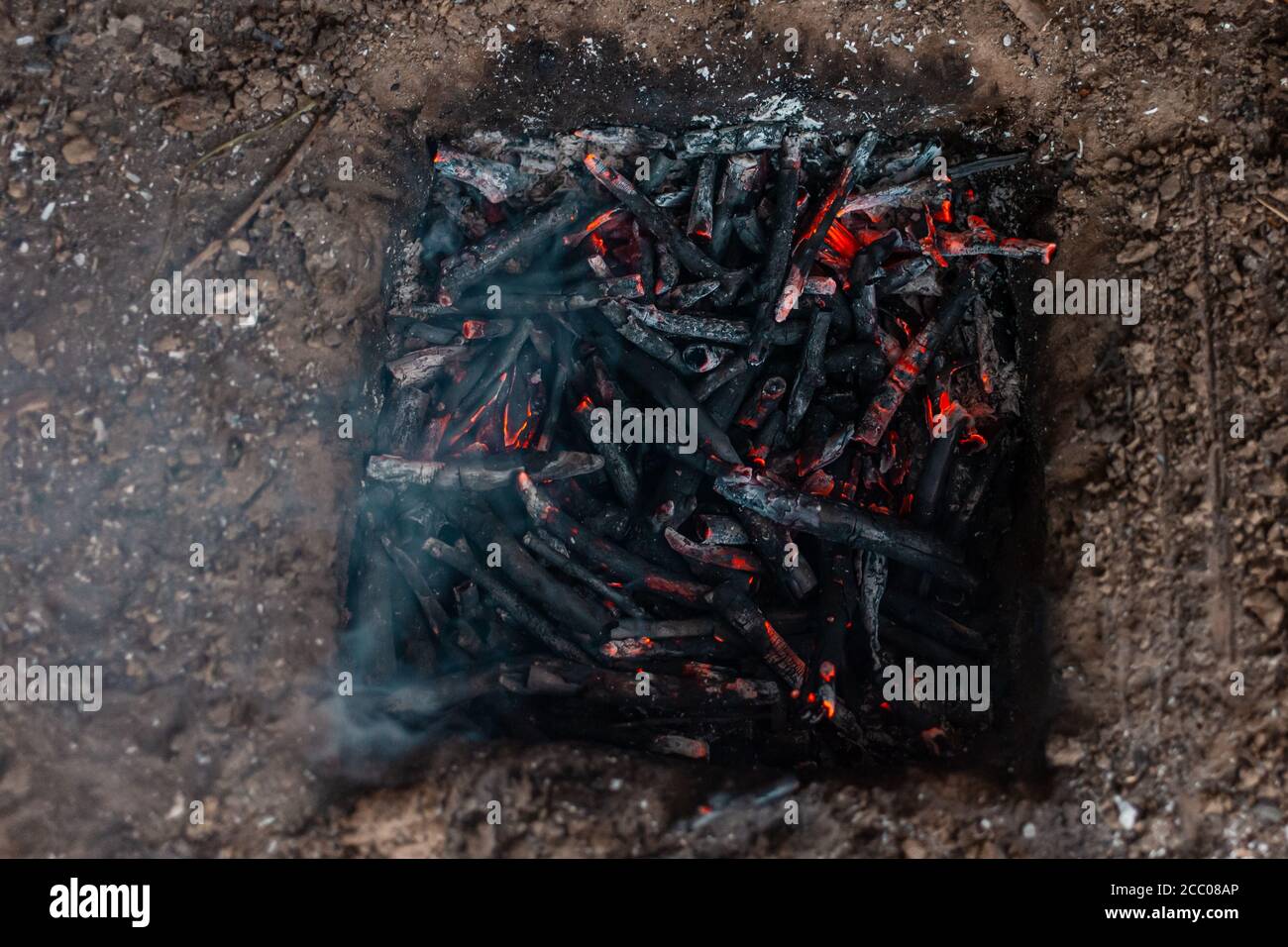 Coals from a campfire in a sand pit. Fire Stock Photo - Alamy