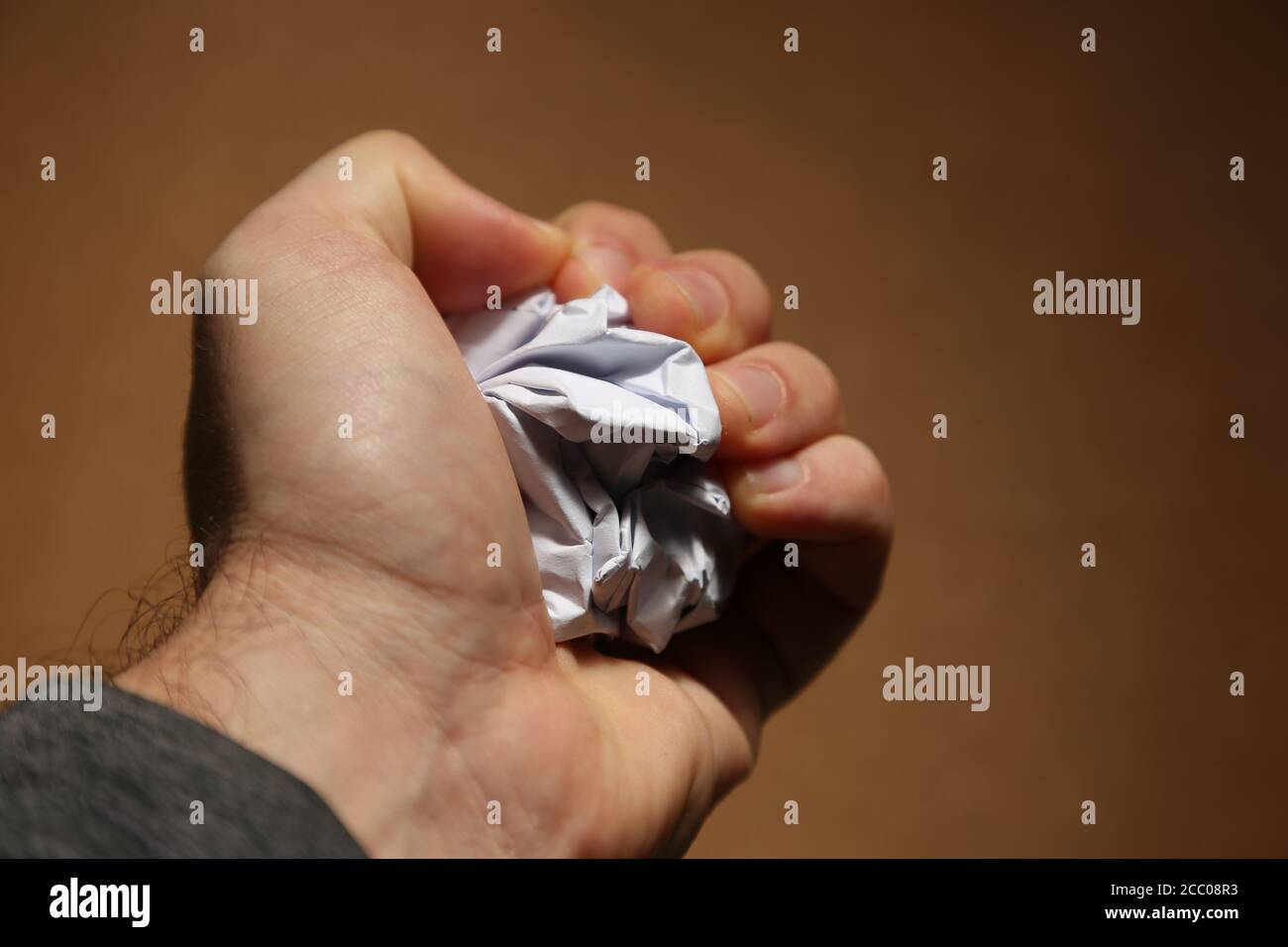 Person holding the scrunched white paper in their hand Stock Photo - Alamy
