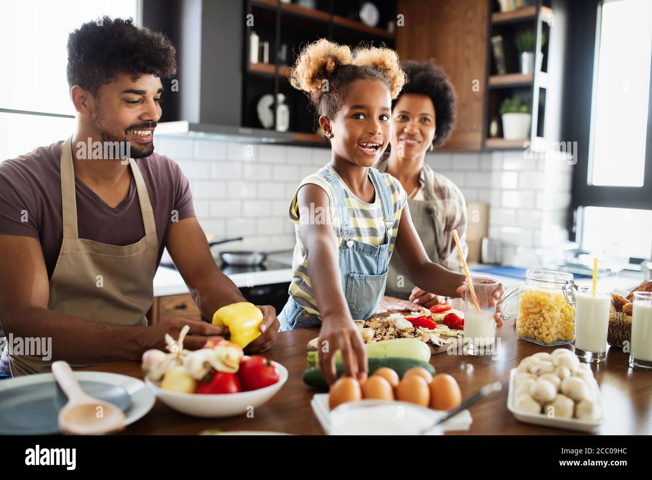 Happy family cooking together food in the kitchen Stock Photo - Alamy