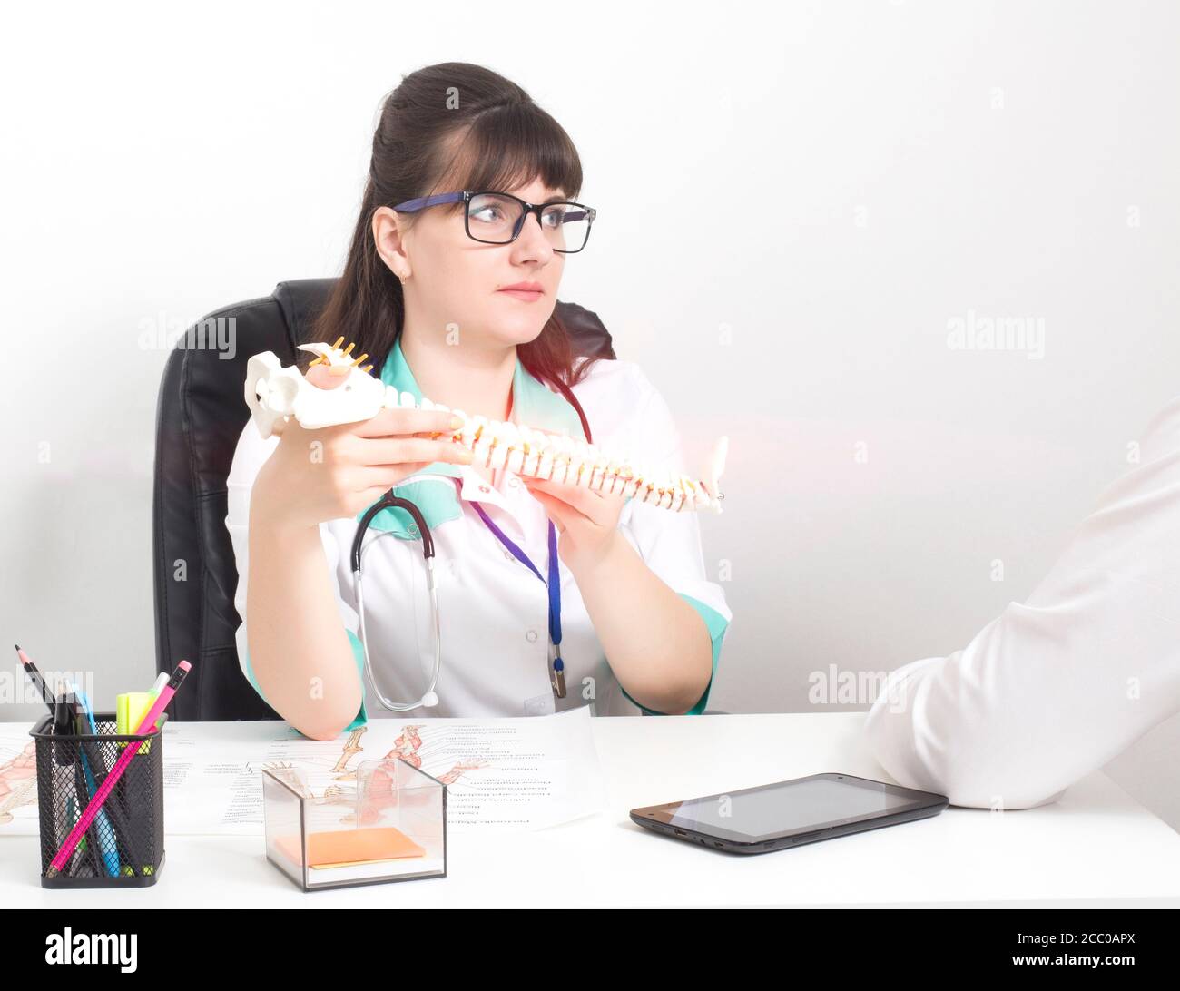 A female orthopedic doctor tells the cause of back pain in a patient ...