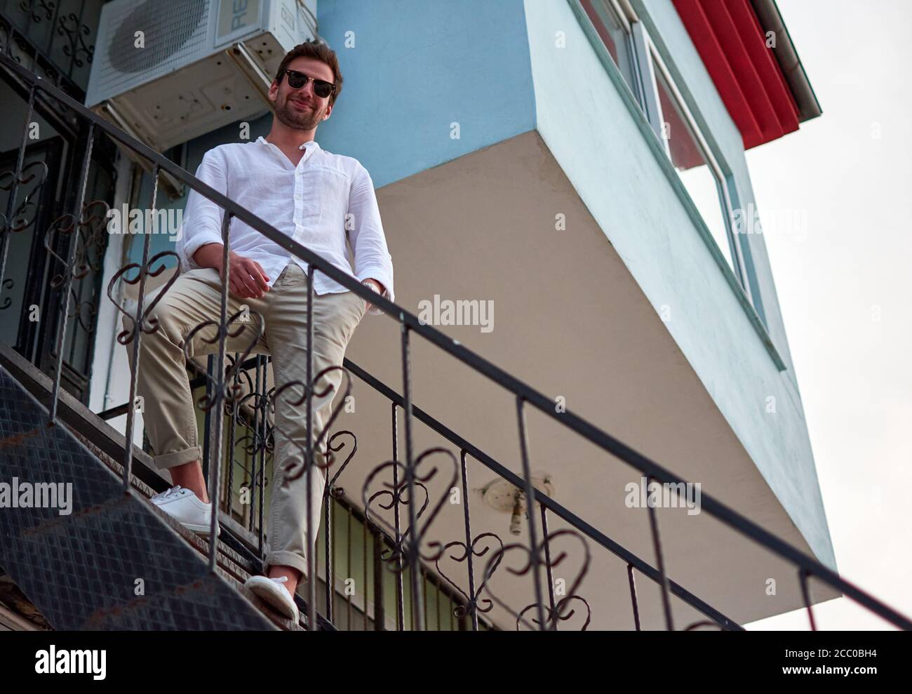 Shot of a male standing on the stairs and smiling Stock Photo - Alamy
