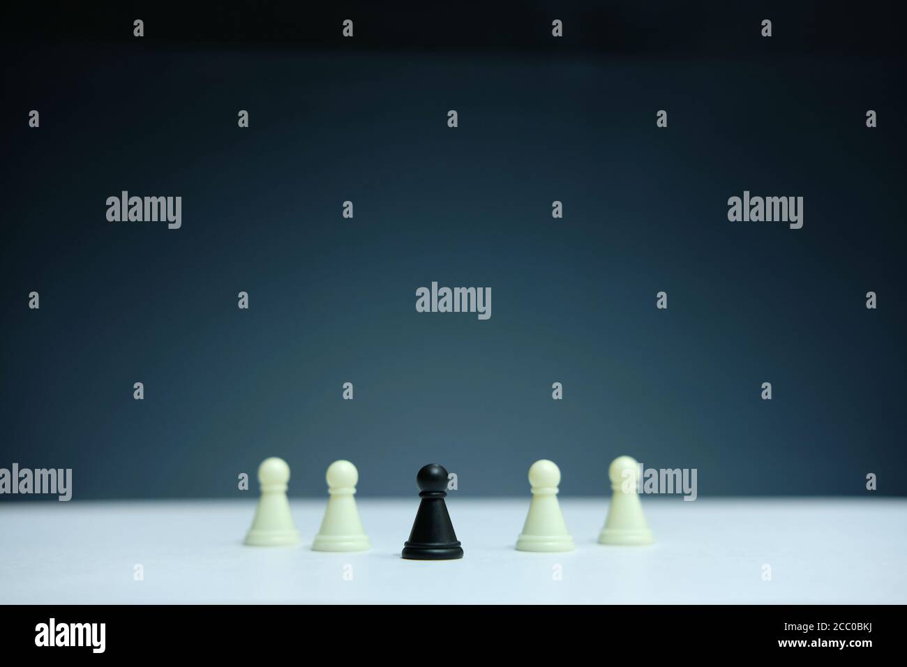 Black pawn piece on white pawn line Stock Photo - Alamy