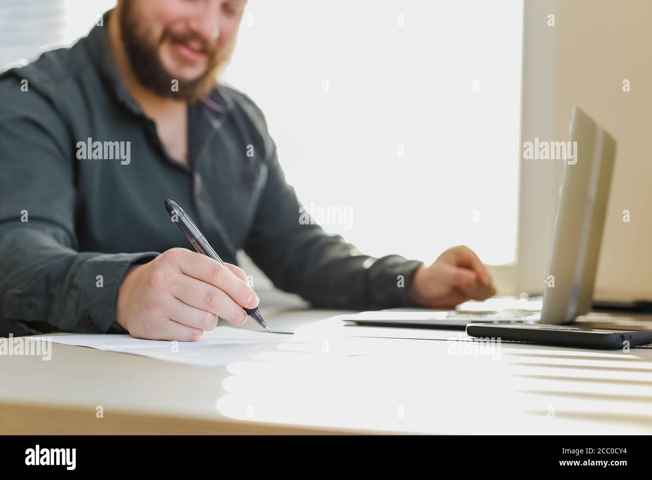 Manager writing letter of resignation and using laptop Stock Photo - Alamy