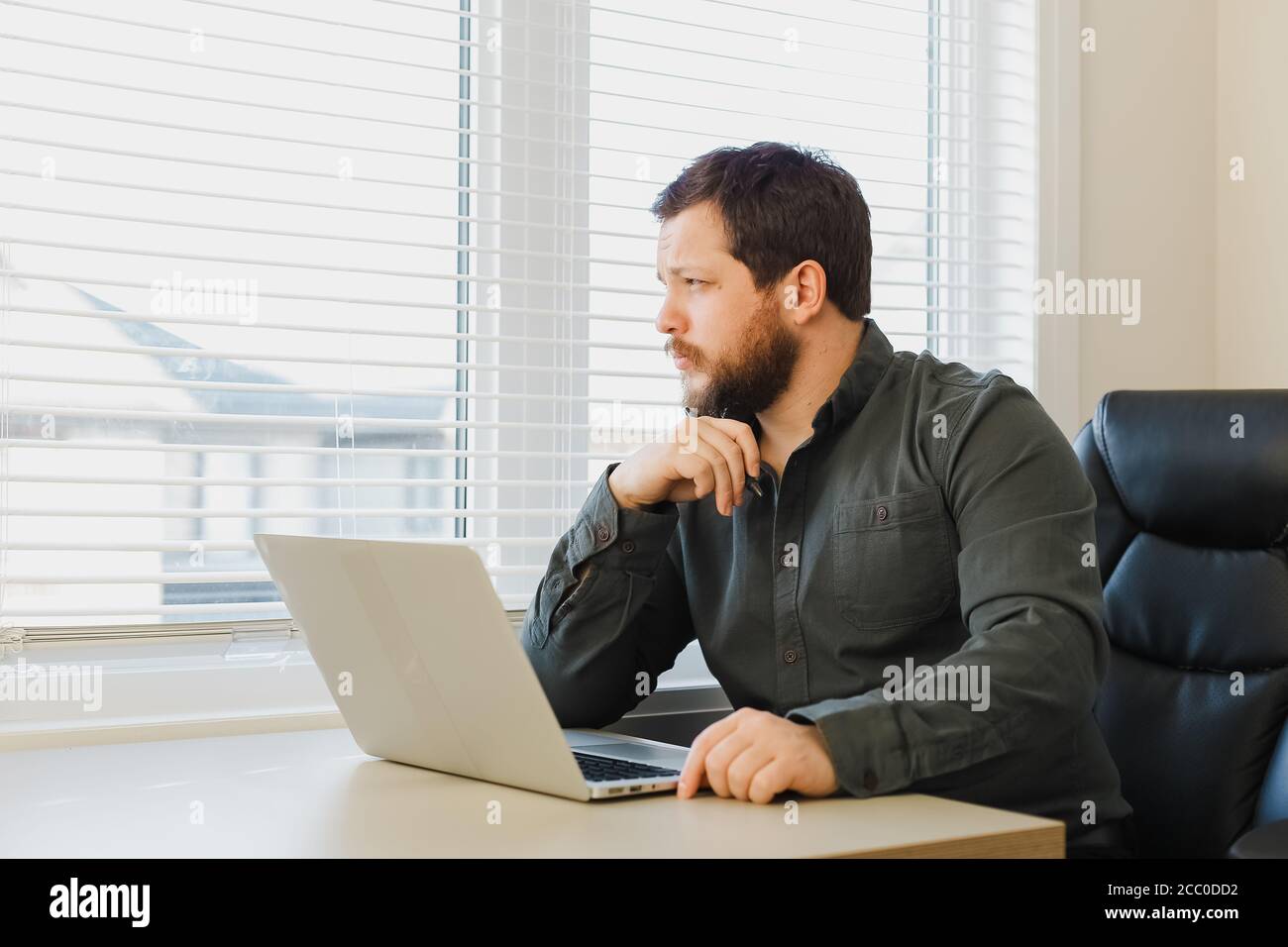 Thinking business director working with pen and laptop at cabinet Stock ...