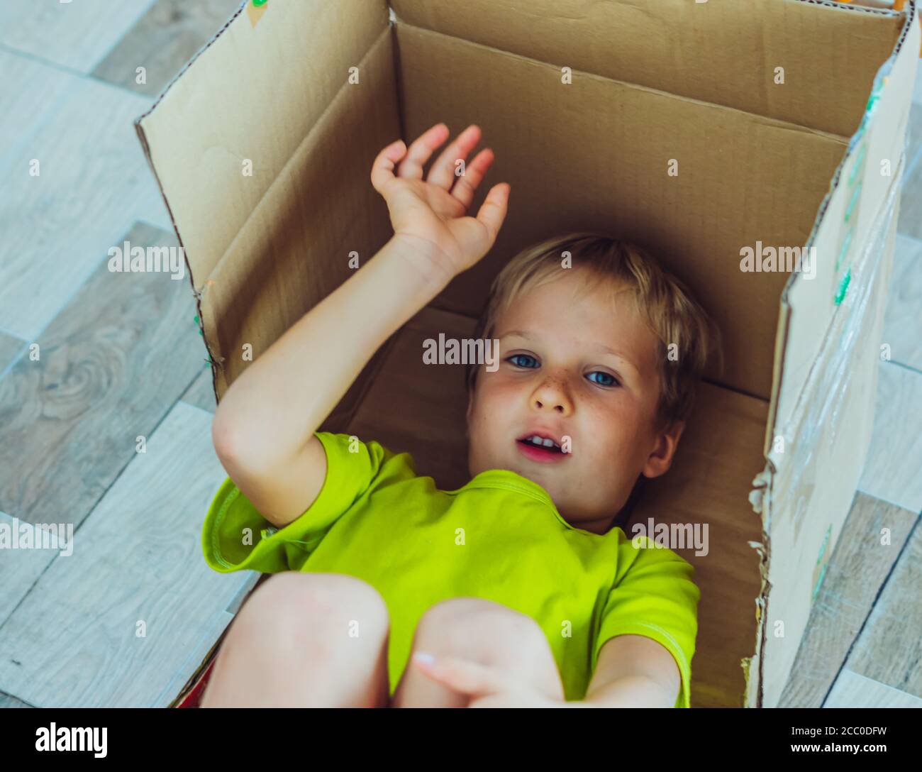 Mischievous boy play hiding in box because does not want to go to ...