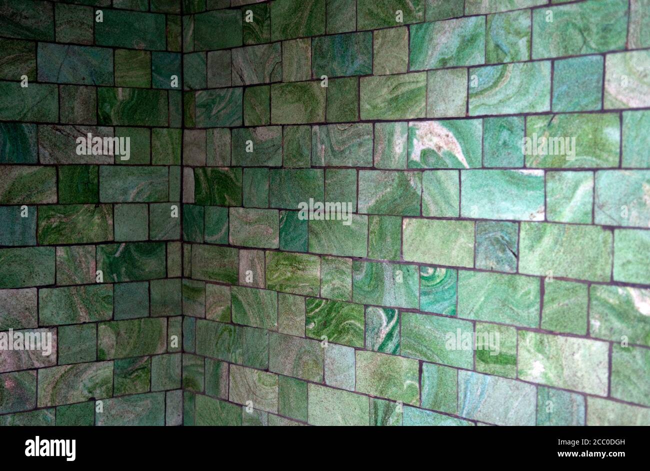 A Corner Of A Room Where The Walls Are Tiled In Green Ceramic Tiles ...