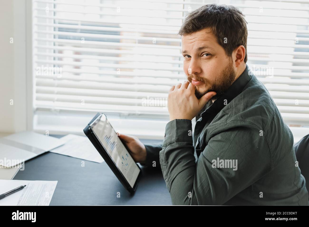 Director using tablet and looking at camera, graphs on screen Stock ...