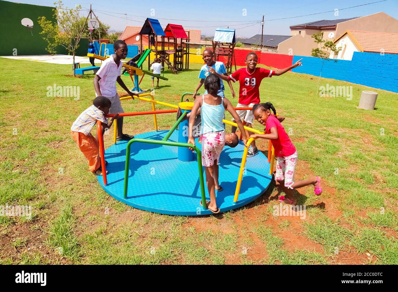 Soweto, South Africa - December 11, 2010: African kids playing merry go ...