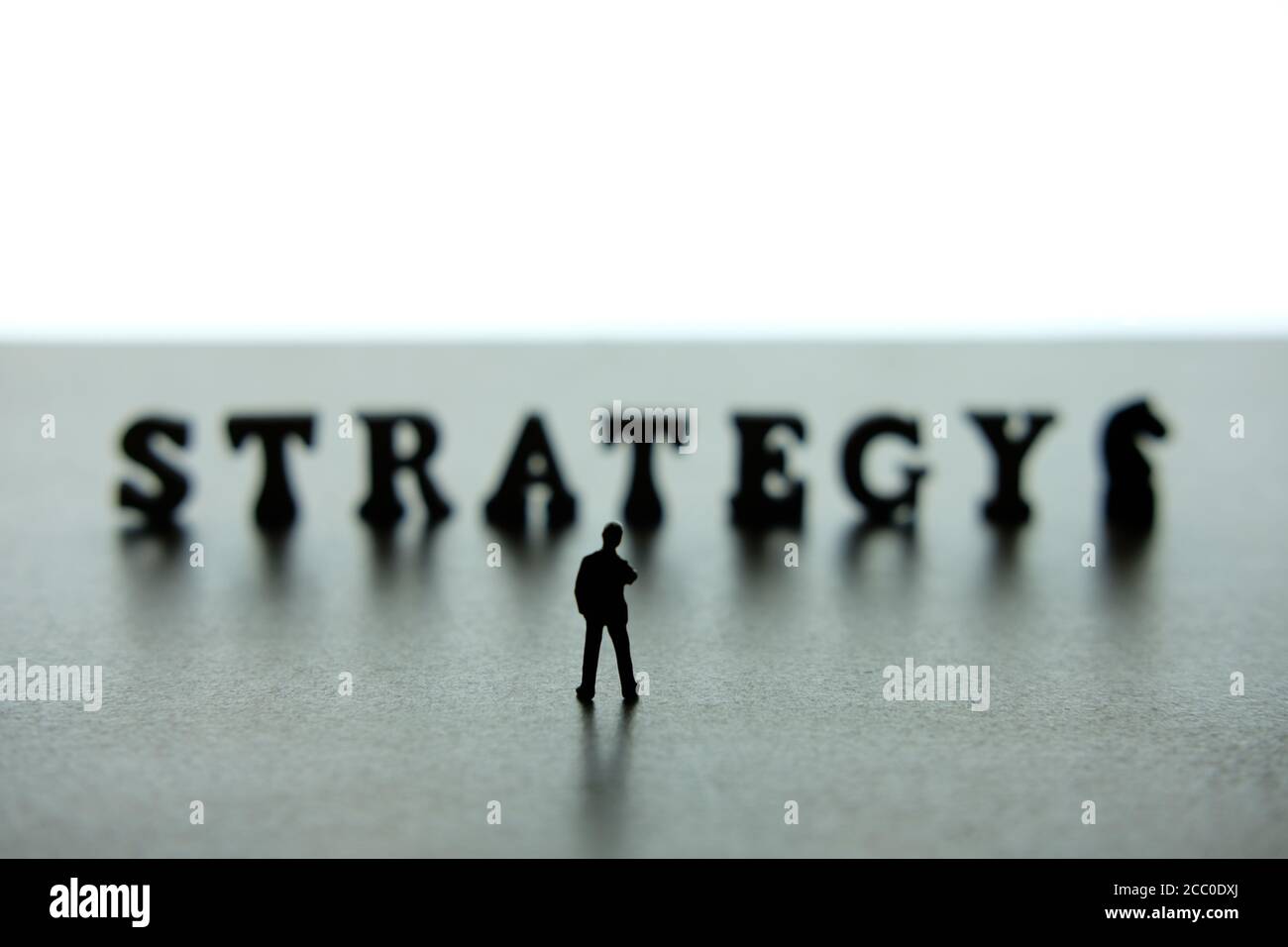 Silhouette of miniature businessmen standing and thinking in front of ...