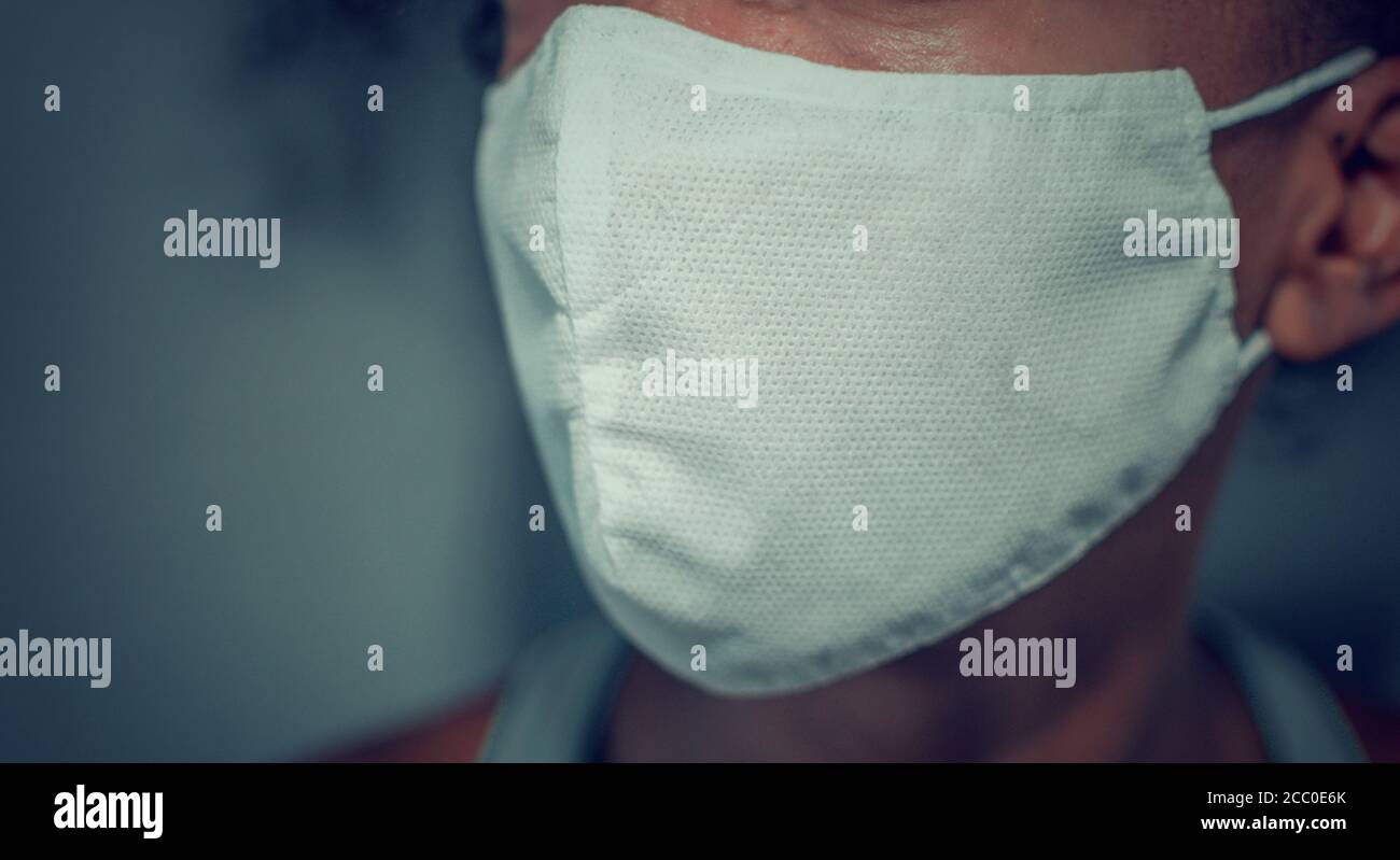 Black woman wearing a face mask. Selective focus on the mask. Blurry ...