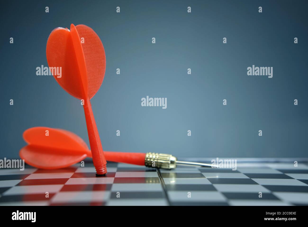 Red dart arrow laying on chess board with dark grey background Stock ...