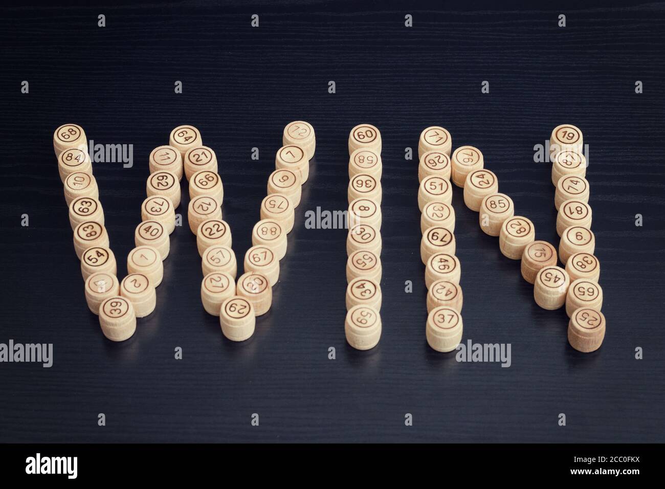 Word Win from wooden barrels. Black wooden table. Lotto Stock Photo - Alamy