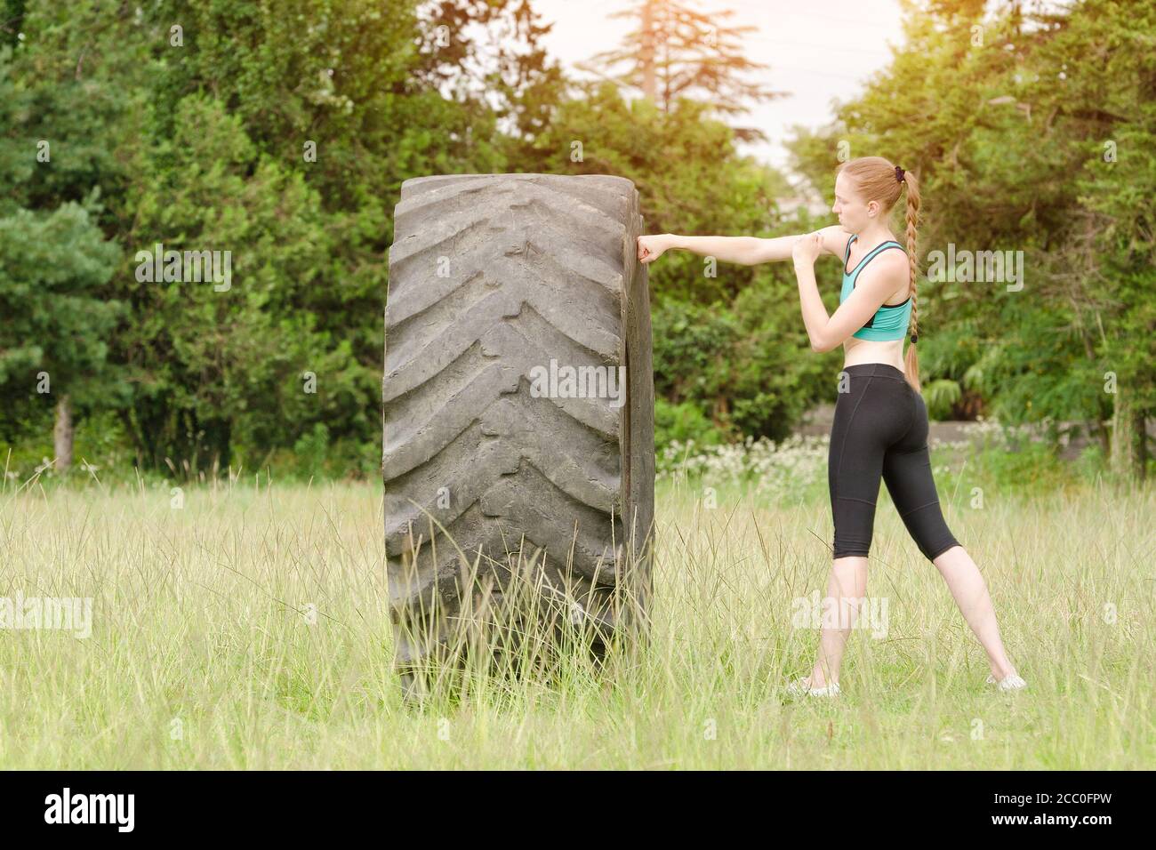 Young woman boxing with the tire. Workout Stock Photo - Alamy