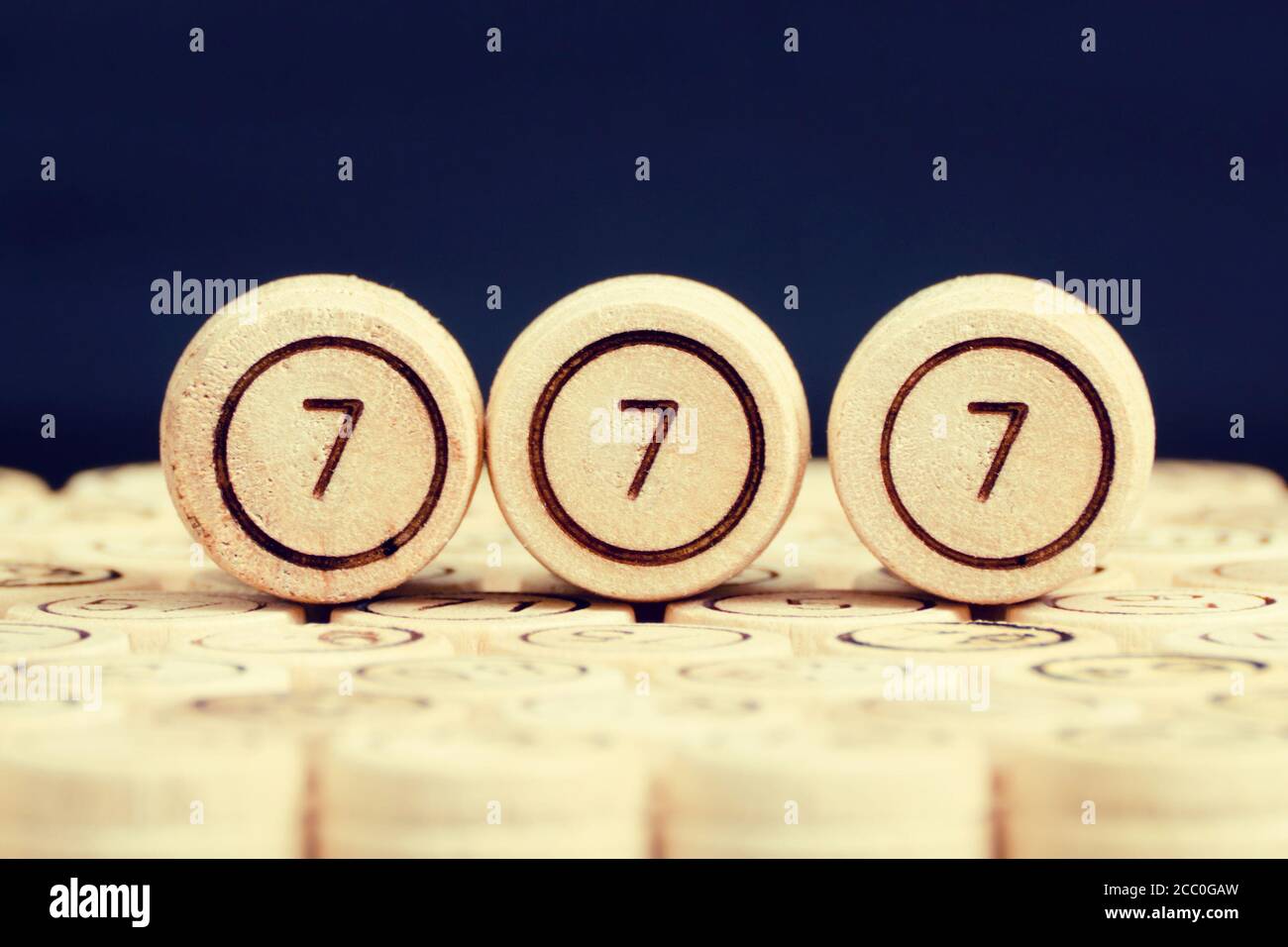 Lucky number 777 on the wooden keg lotto. Black background. Close up ...