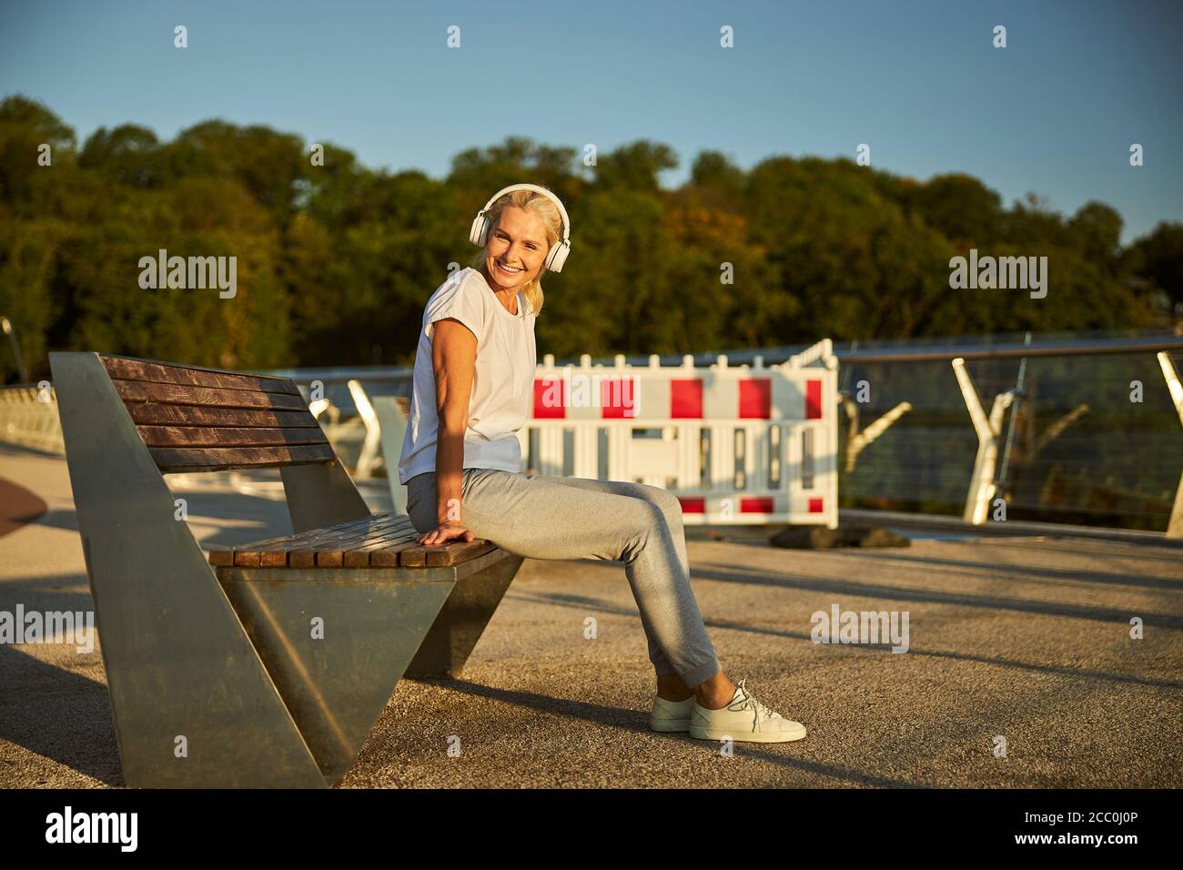 Charming woman sitting on bench hi-res stock photography and images - Alamy