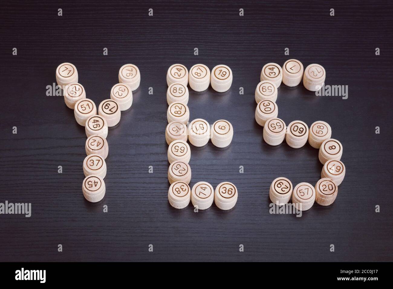 Word YES from wooden barrels. Black wooden table Stock Photo - Alamy
