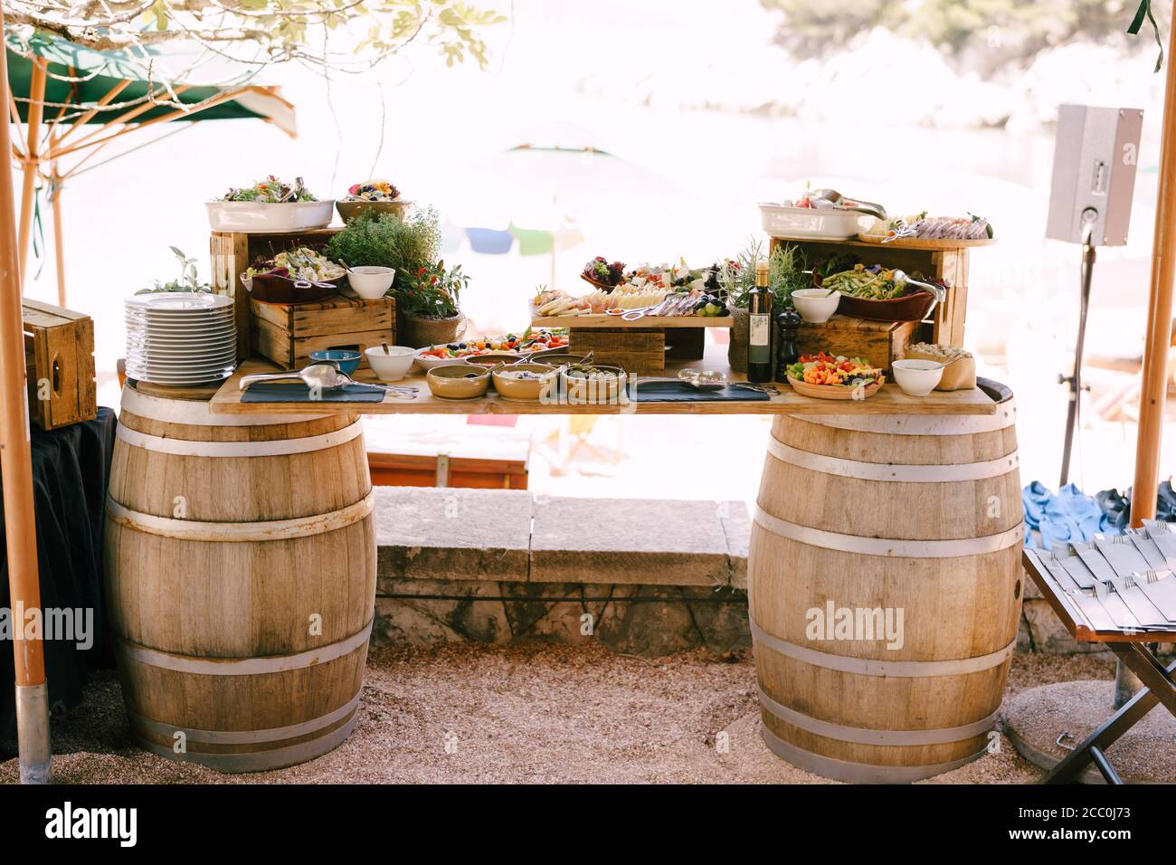 An impromptu table of two wine barrels and a wooden bar with delicacies ...